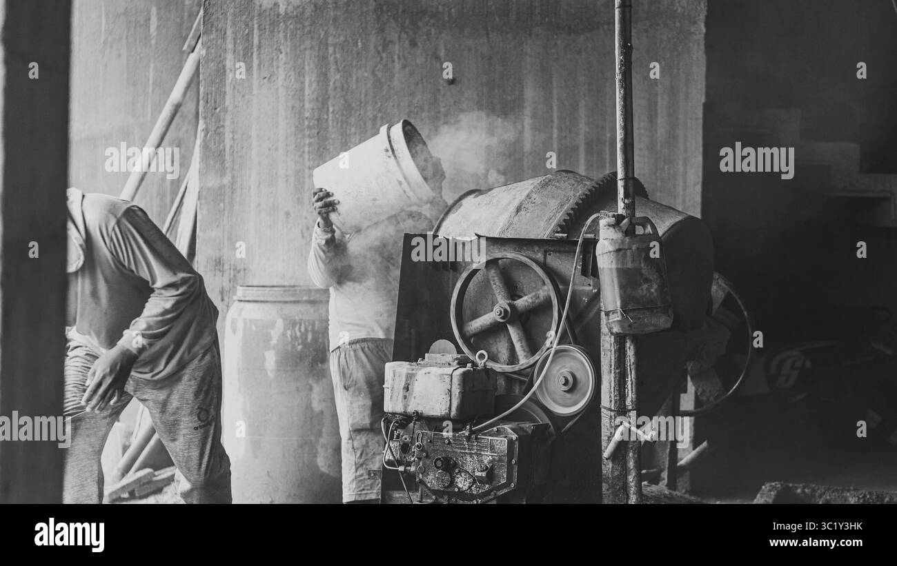 Construction workers collaborate in mixing cement, showcasing solid ...