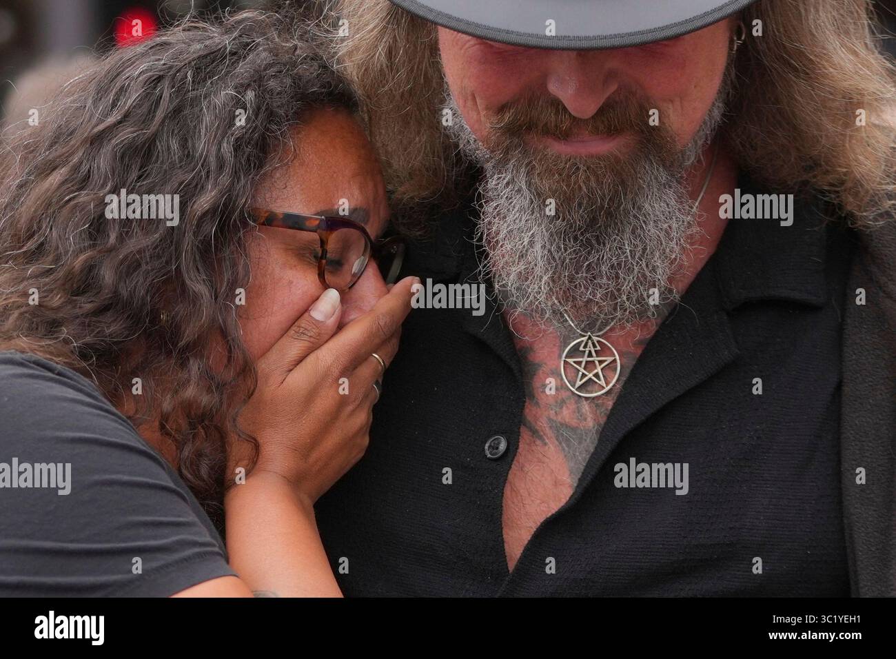 Music fans react after they lay flowers to commemorate the death of ...