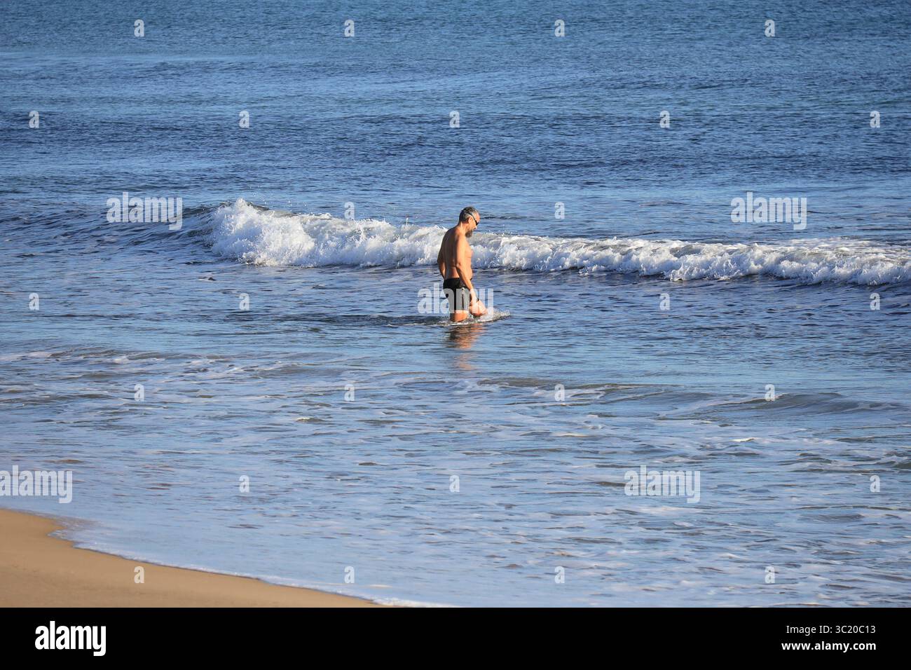 Arenales del Sol, Alicante, Spain- June 20, 2025: Man entering the sea ...