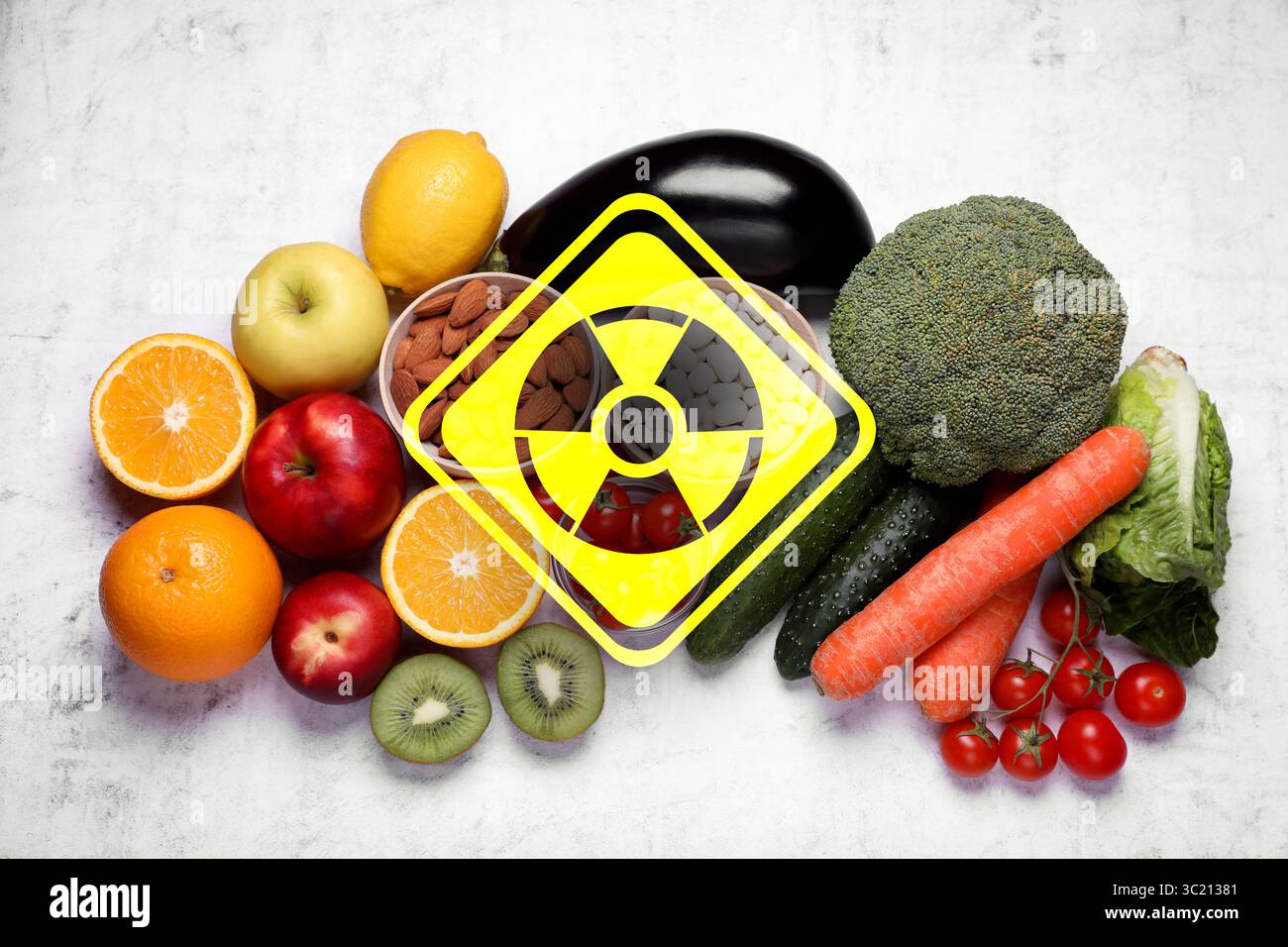 Fresh vegetables and fruits on white table and radioactive sign, top ...