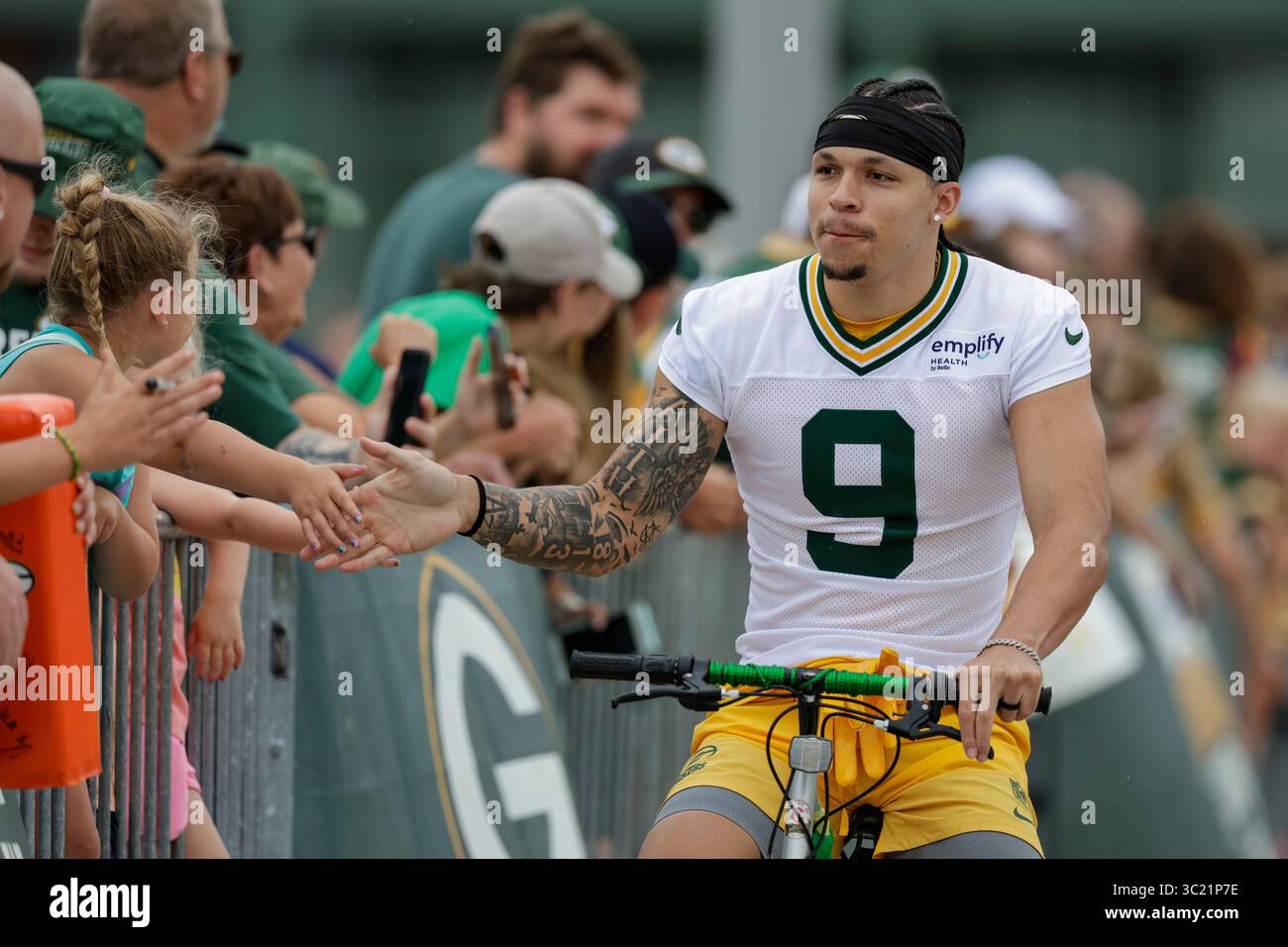 Green Bay Packers' wide receiver Christian Watson rides a bike to practice at the team’s NFL ...