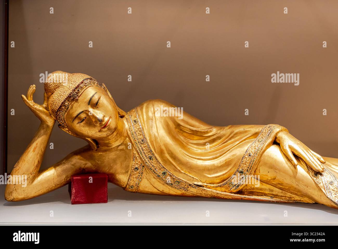 Golden statue of young Buddha laying down in a pose Stock Photo - Alamy