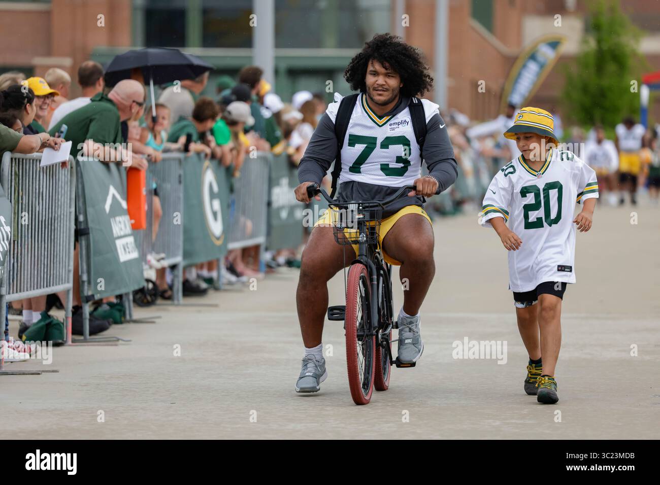 Green Bay Packers' guard John Williams rides a bike to an NFL football practice Wednesday, July ...