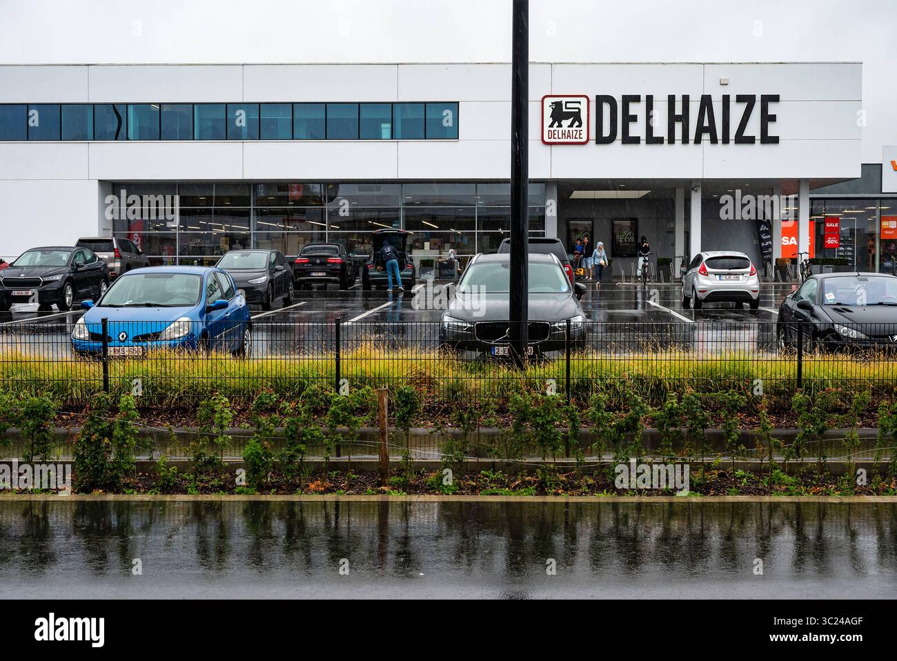 Delhaize supermarket and parking lot in Maldegem, East Flanders, Belgium 6 July 2025 Stock Photo ...