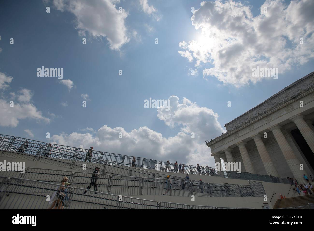As the temperature reaches the low 90's, people make their way along ...