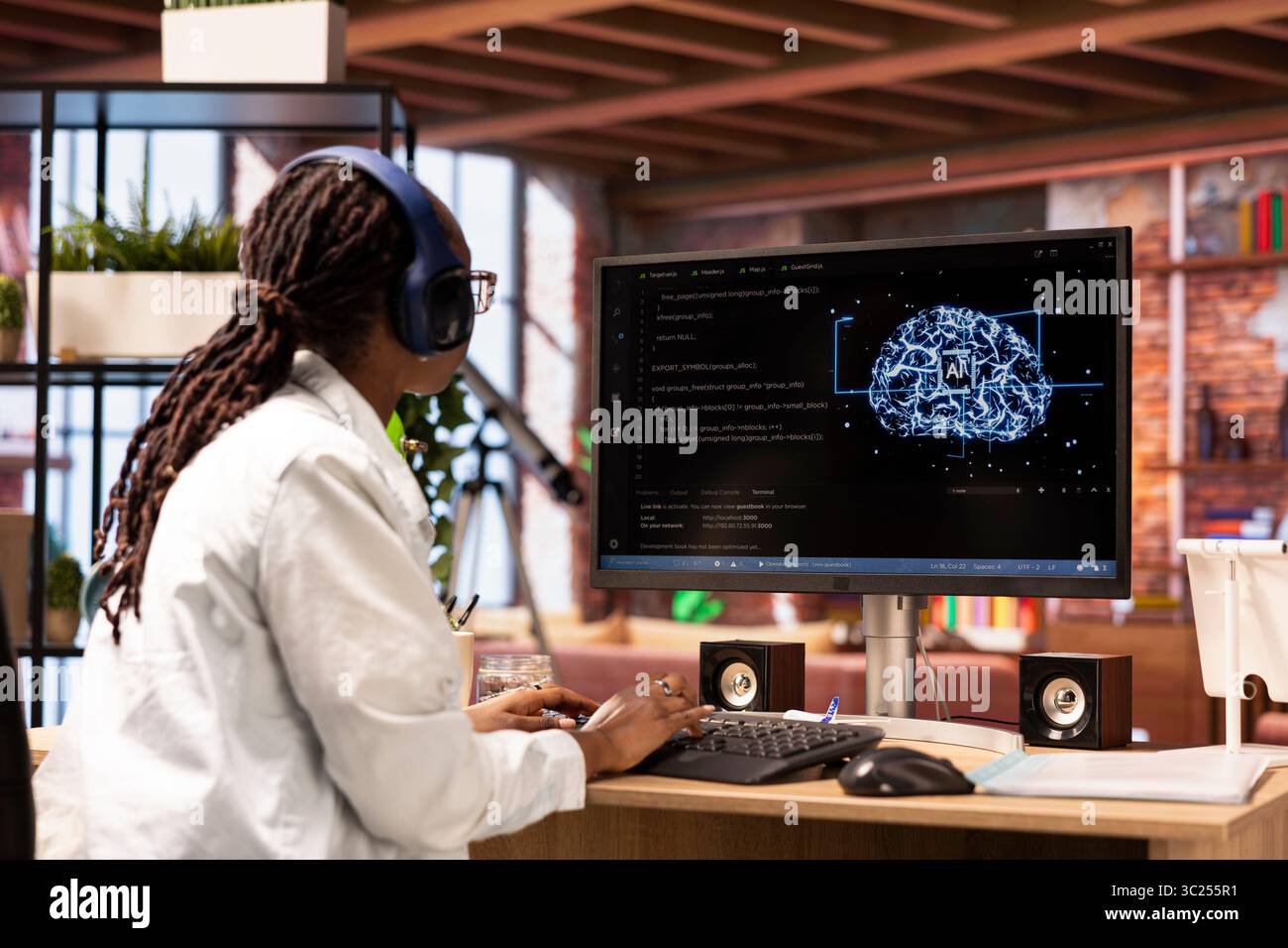 Software developer typing on PC keyboard, wearing headphones, using ...