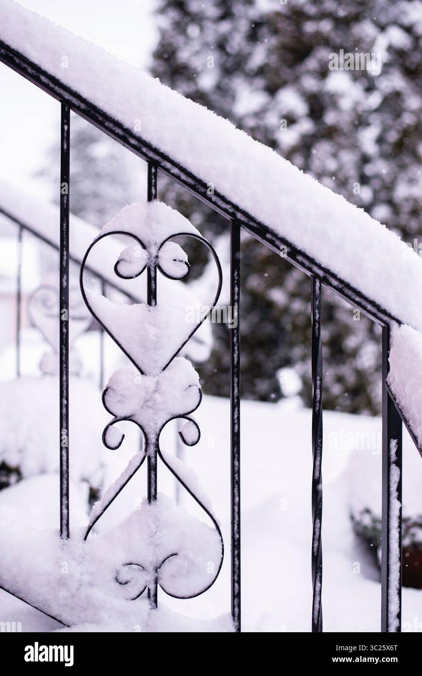 Heavy snow on a residential porch railing piling up on the decorative ...