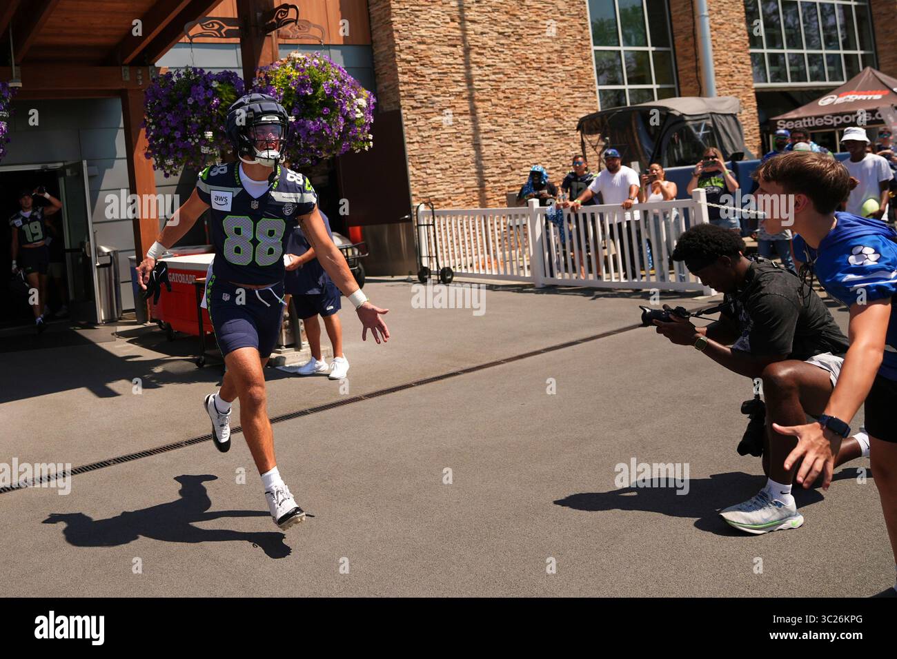 Seattle Seahawks tight end AJ Barner greets fans while running out to ...