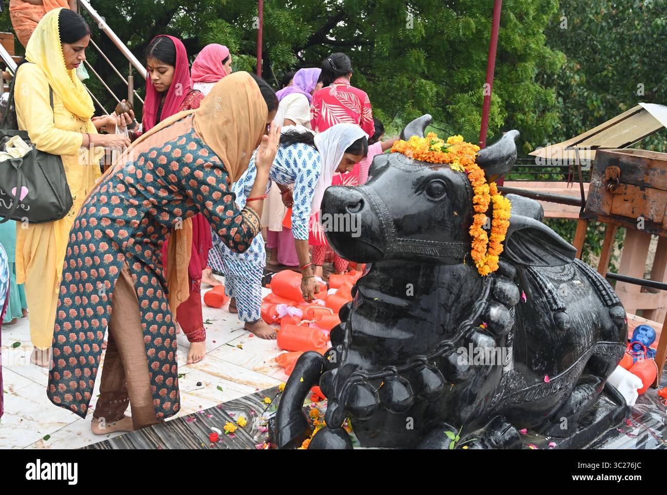 NEW DELHI, INDIA - JULY 23: Hindu devotees offering water and milk ...
