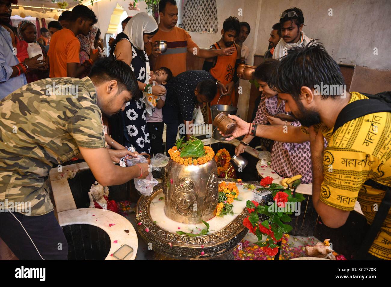NEW DELHI, INDIA - JULY 23: Hindu devotees offering water and milk ...