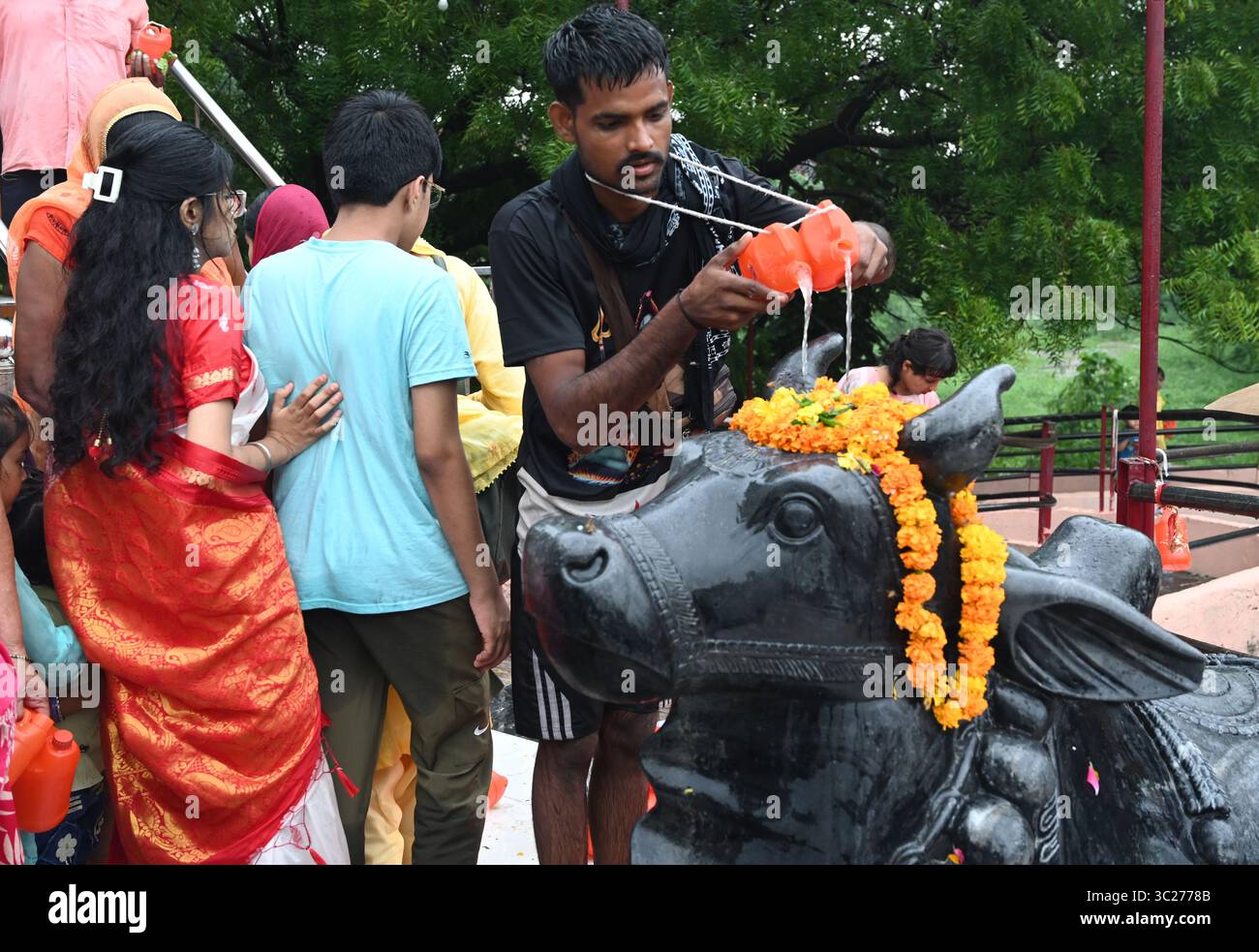 NEW DELHI, INDIA - JULY 23: Hindu devotees offering water and milk ...