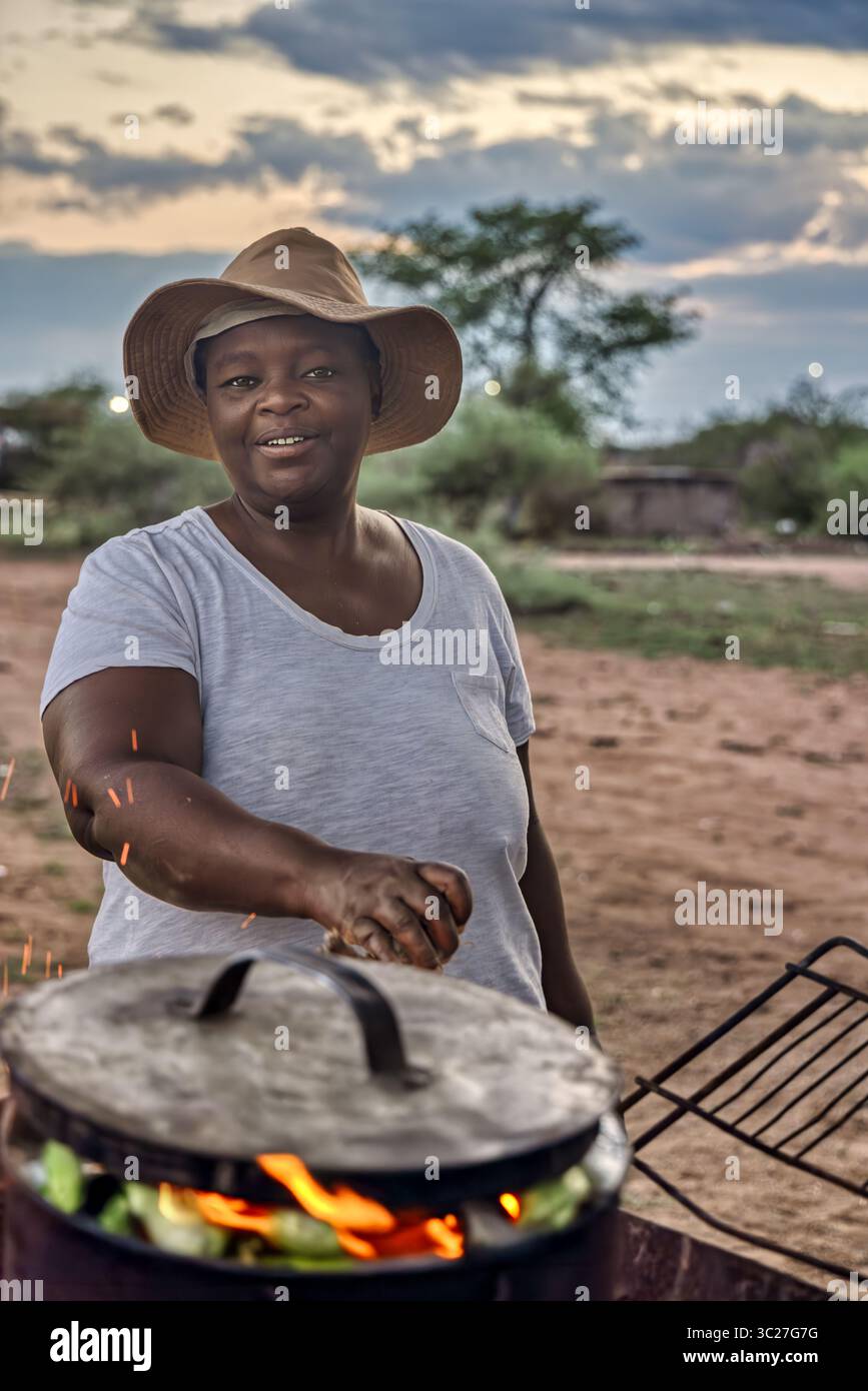 African street vendor, woman selling boiled corn, maize on the fire on ...