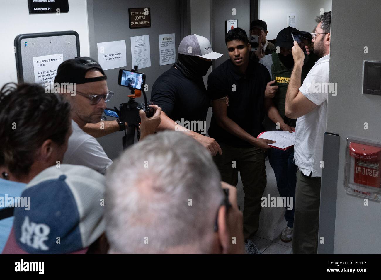 Federal Agents detain a man at the Executive Office of Immigration ...