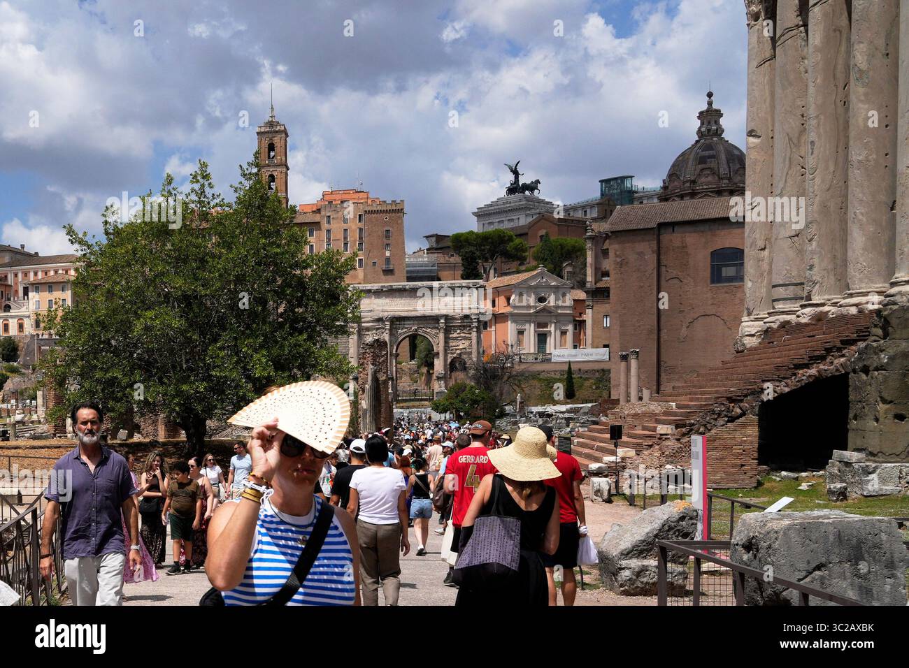 Tourists use use fans and sun hats as they visit the Forum in Rome on ...
