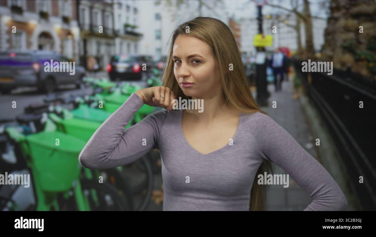 Young woman making a gesture on a busy city street with lime green ...