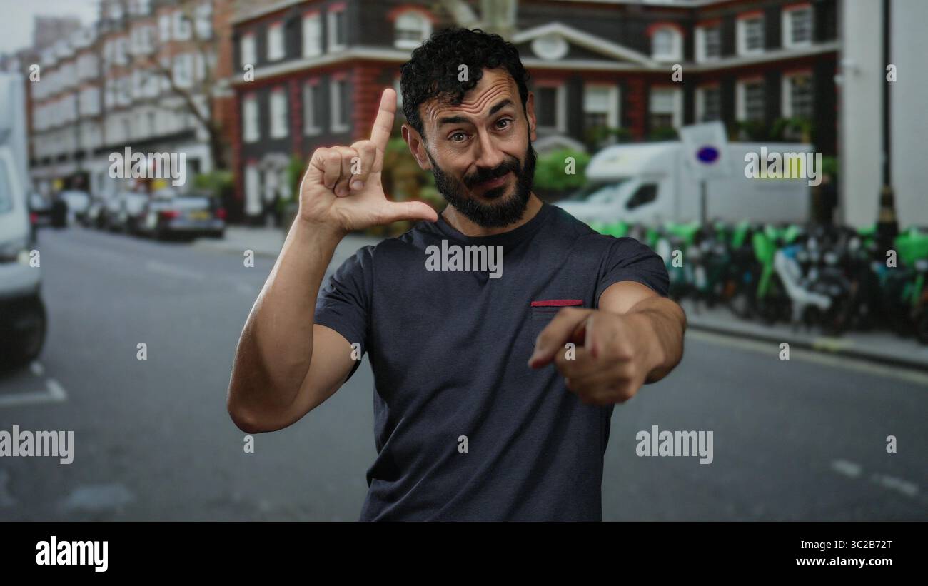Hispanic man outdoors on a street making loose hand gestures in front ...
