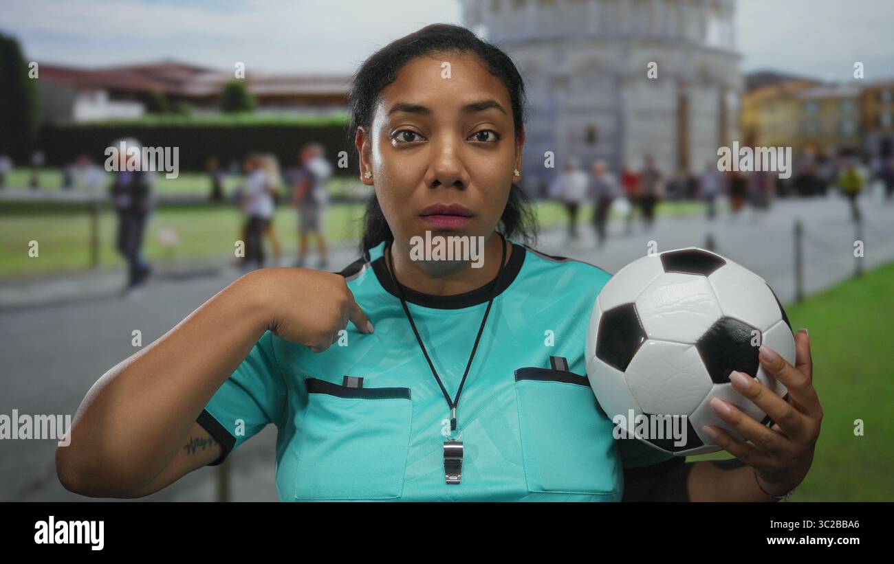 Smiling referee woman wearing turquoise jersey holds soccer ball by ...