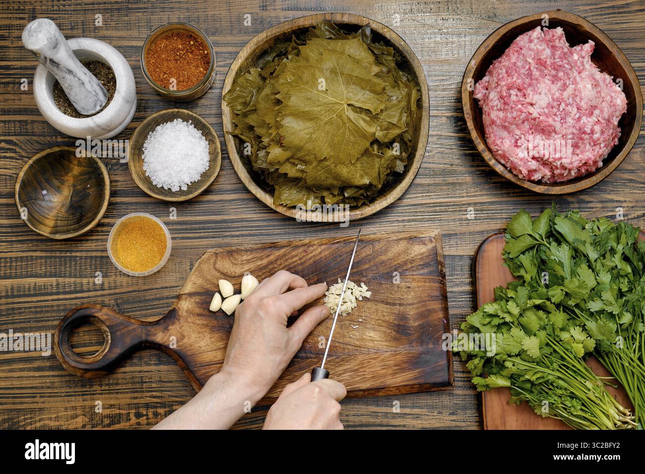 Preparing dolma at home involves chopping garlic and herbs while ...