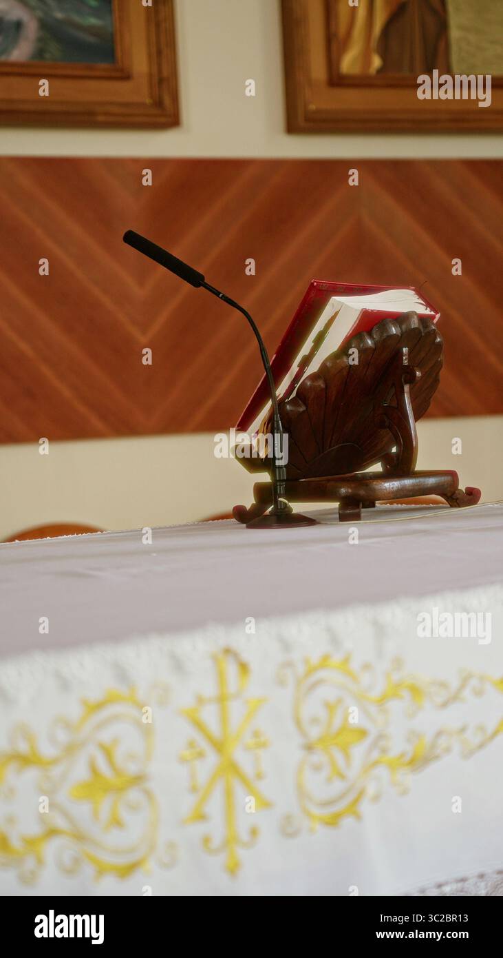 Pulpit with microphone and open bible on altar inside a church setting ...