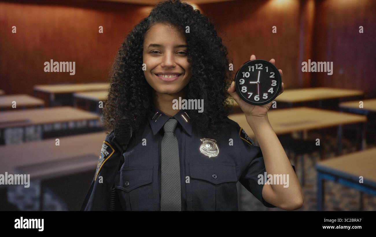 Woman officer in uniform holding clock in classroom demonstrating time ...