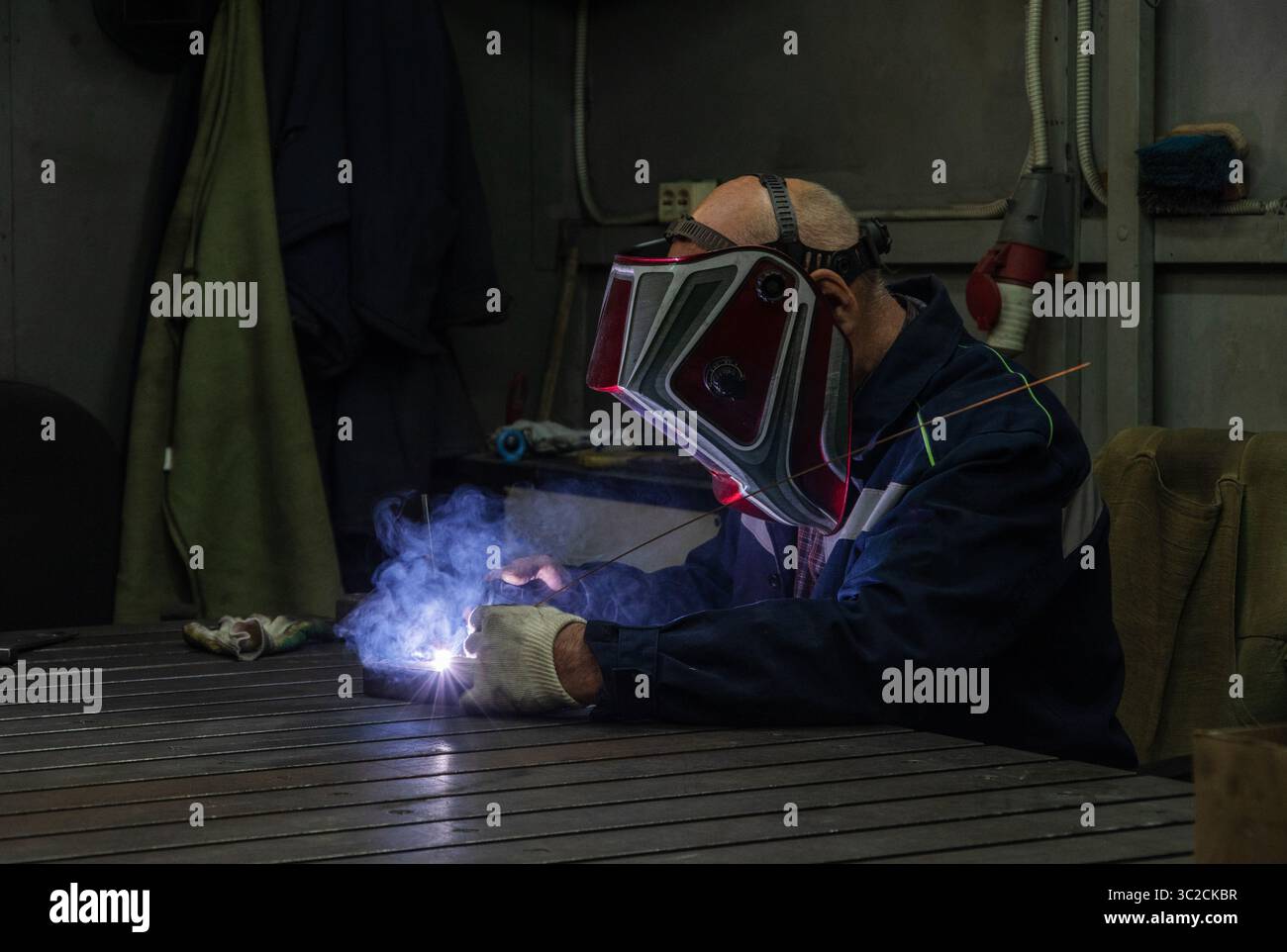 Welder welding metal with sparks, realistic style, dark background ...