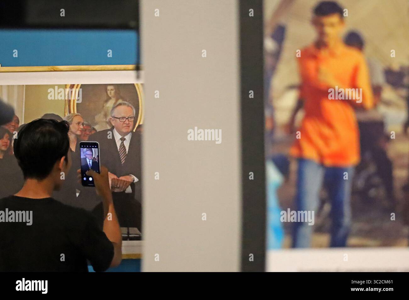 July 24, 2025, Banda Aceh, Aceh, Indonesia: Visitors capture archive photos of the signing of ...