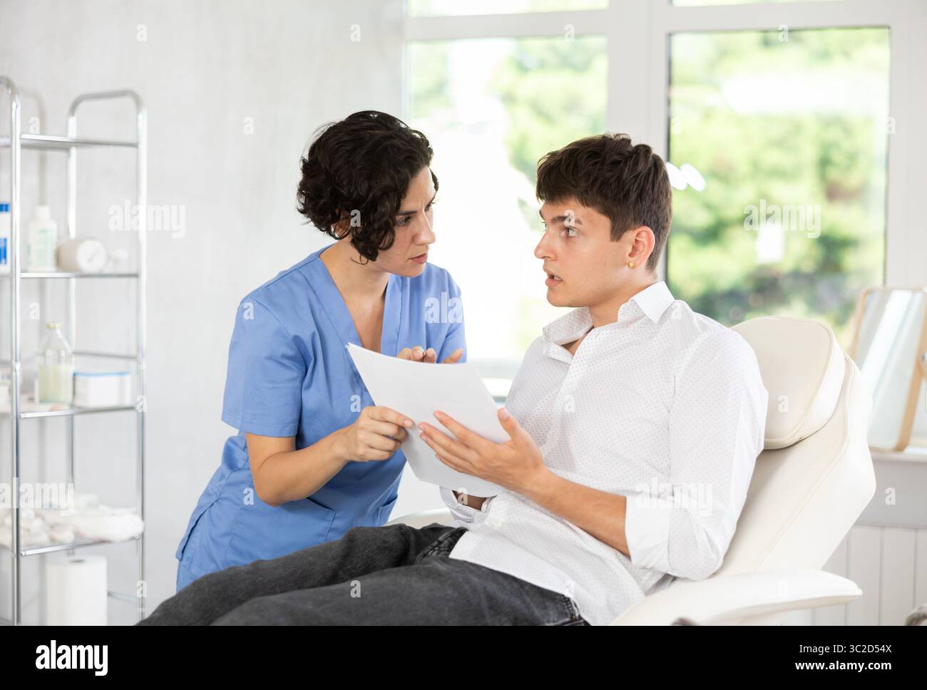 Male patient signs the contract for operation in the clinic of body ...