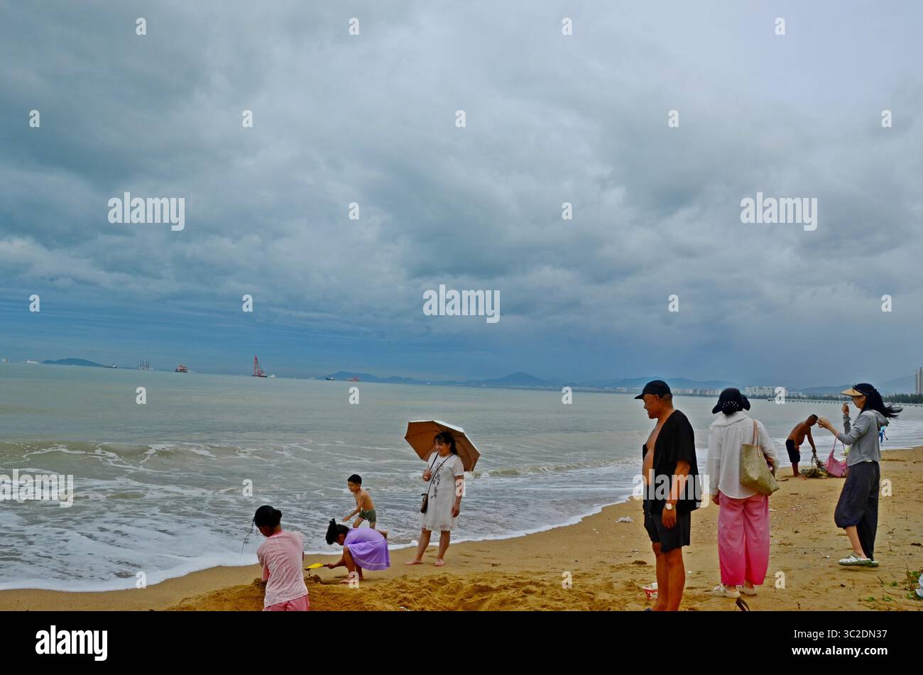 Tourists play at the seaside in Sanya City, southernmost China's Hainan ...