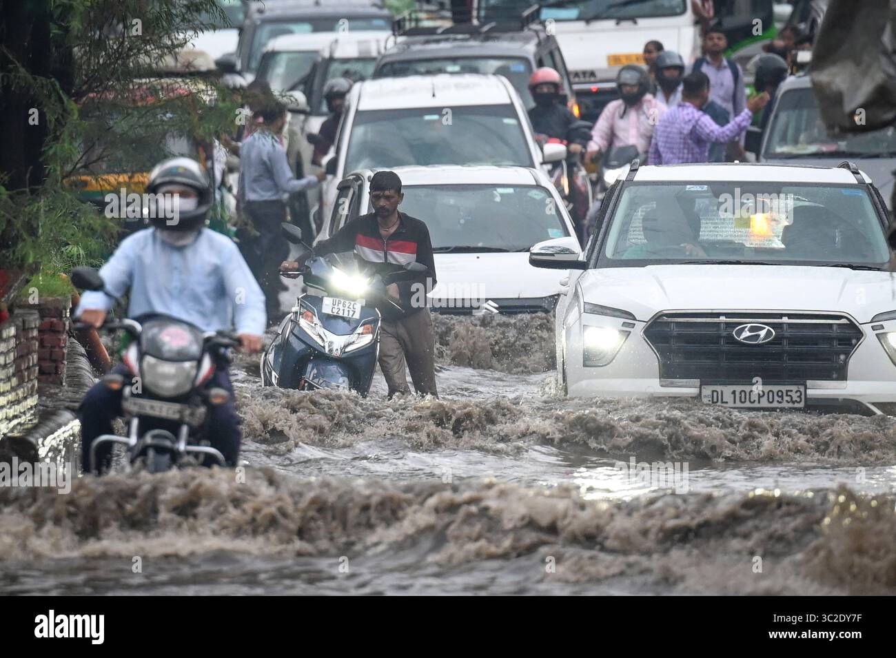 NEW DELHI, INDIA - JULY 23: Commuters seen wading through a water logged stretch over Rohtak ...