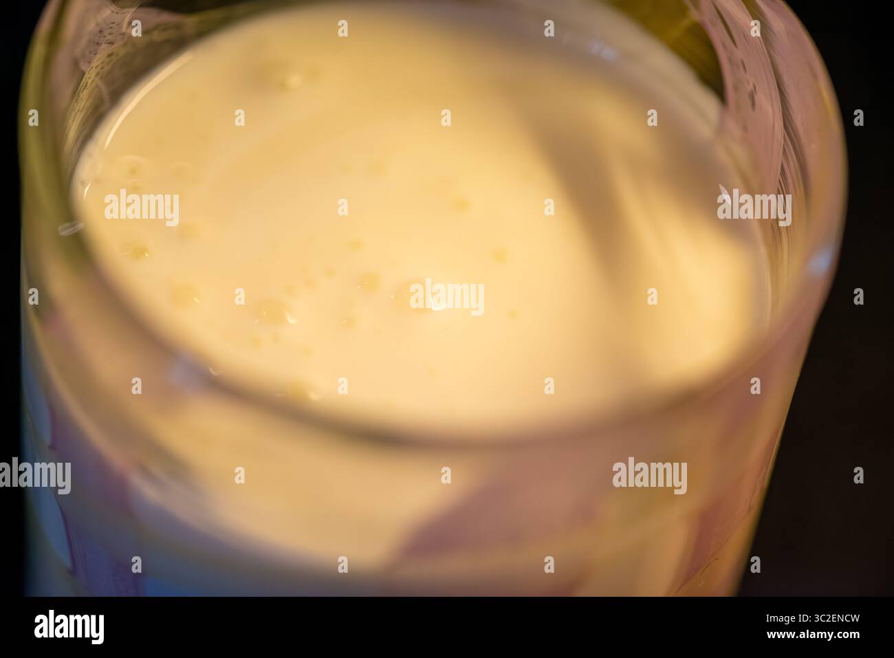 A clean, high-resolution photo of creamy white kefir being poured into ...