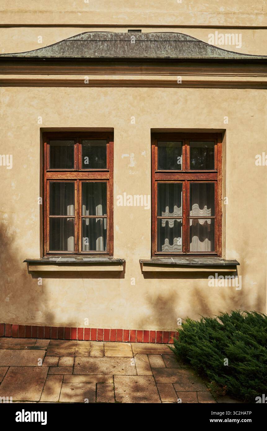 The two windows on the building are old and have wooden frames. The ...