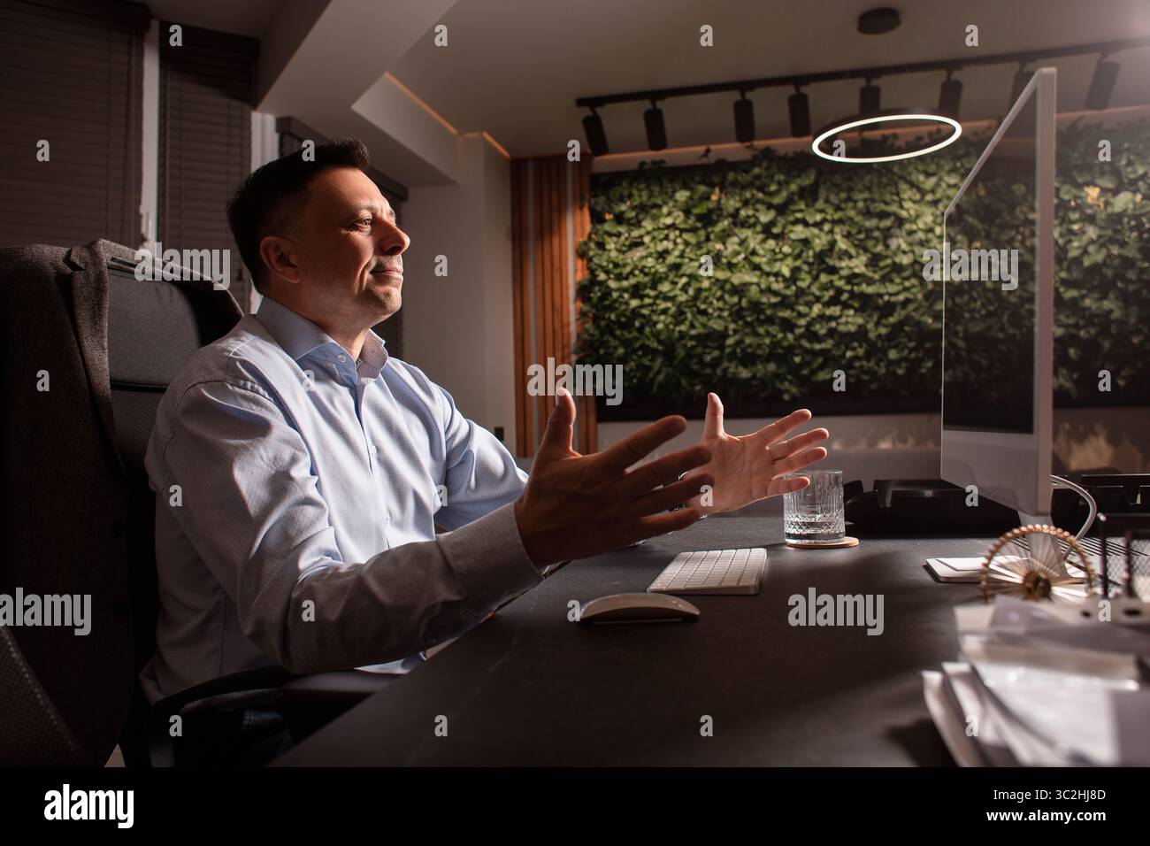Upset businessman raises his hands in frustration while working at a ...