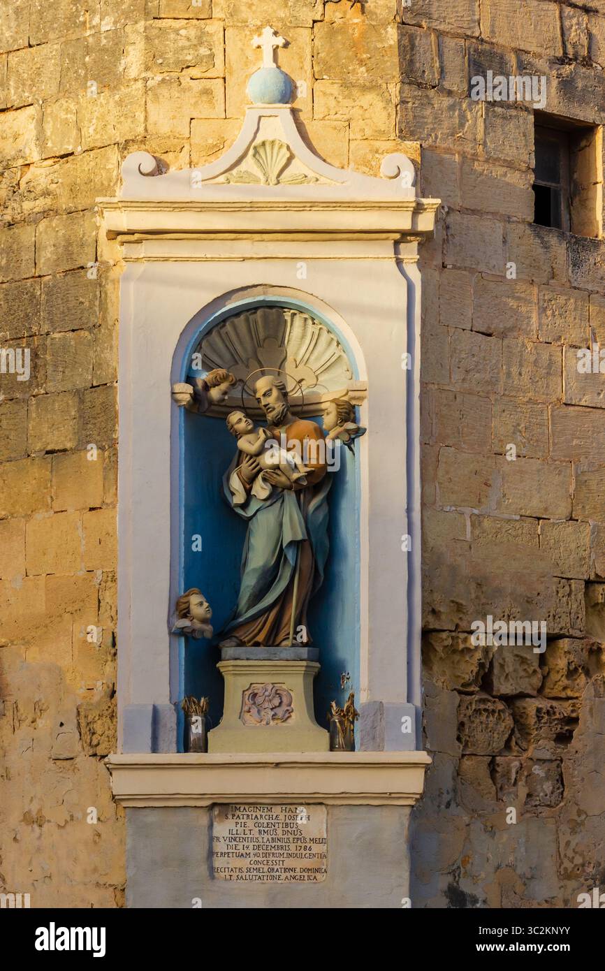 Religious Statue on Historical Stone Wall Background in Sunlight Stock ...