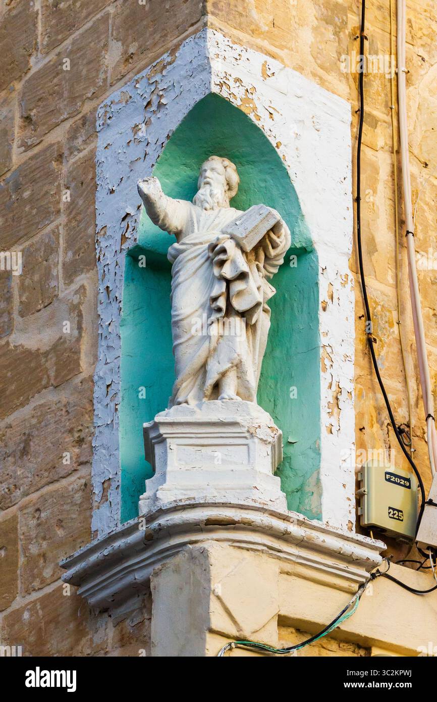 White Stone Religious Statue Integrated into Rustic Building Corner ...