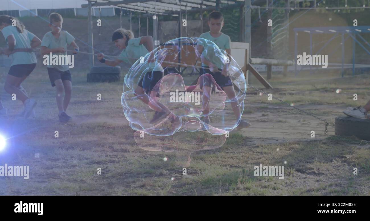 Six children in sportswear pulling rope during tug-of-war on field ...