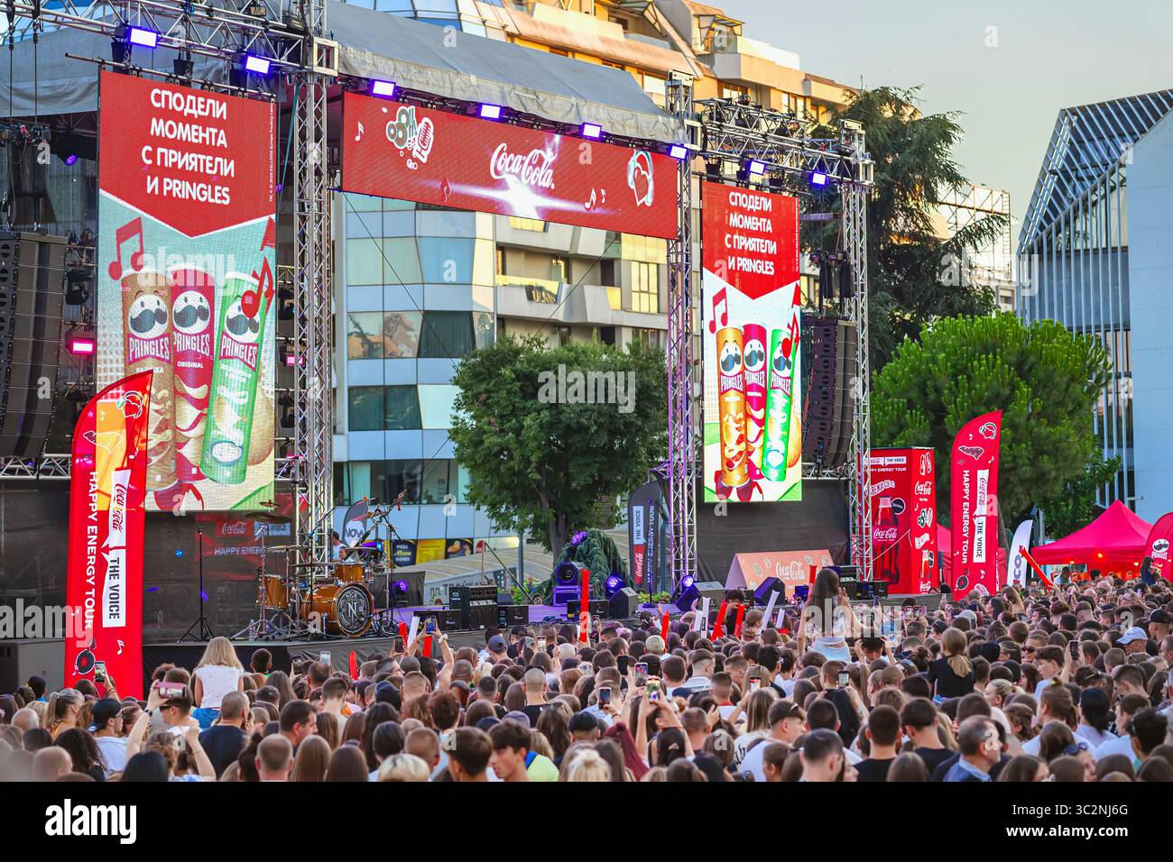 People crowd at open air concert with Coca-Cola and Pringles branding ...