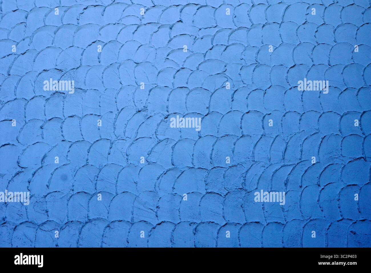 Closeup of a blue plastered stucco wall with trowel marks forming a ...