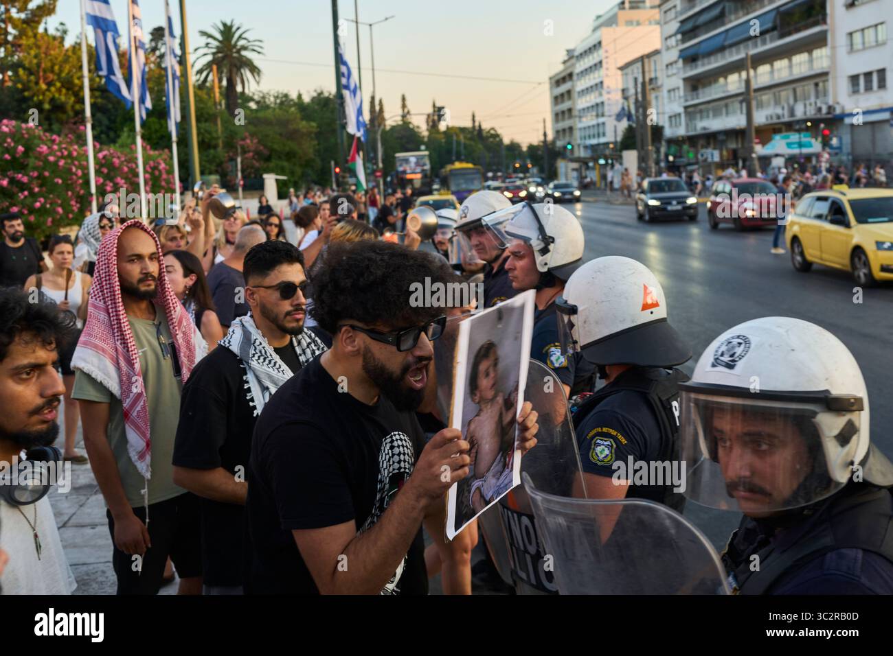 Protesters chant slogans in front of riot police during a demonstration ...