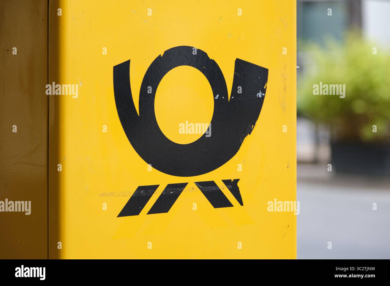 German yellow post box with Deutsche Post logo on city street Stock ...