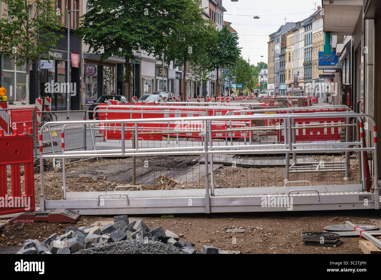 Urban street under construction with red barriers and fencing Stock ...