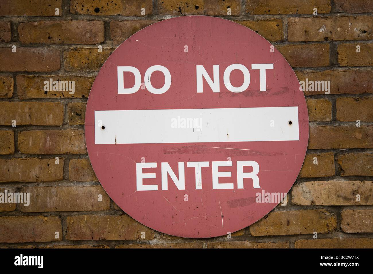 Red "DO NOT ENTER" sign mounted on a wall, serving as a clear warning ...