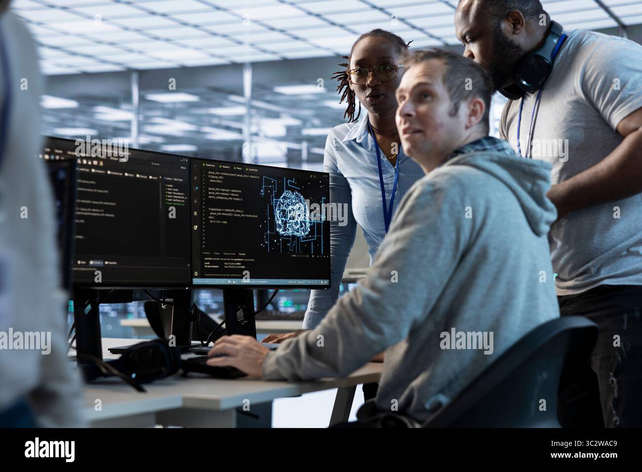 Engineer helped by colleagues to find errors in code while doing checkup on server room used for ...