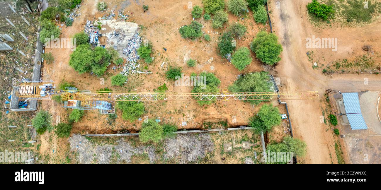 Abandoned construction site with a crane in the middle, surrounded by ...