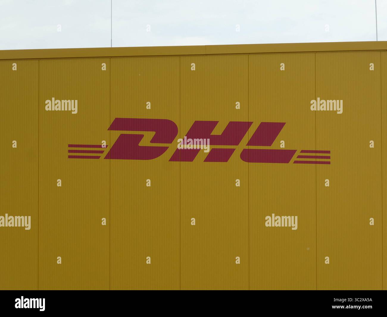Logo, Schriftzug von DHL Deutsche Post an einer gelben Wand des ...