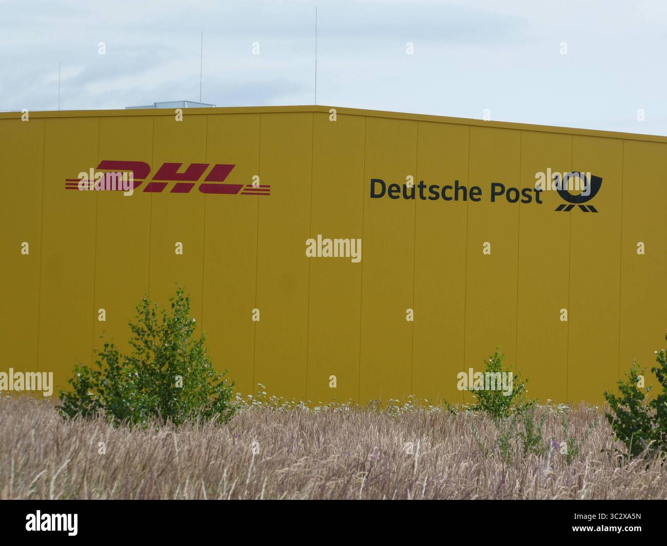 Logo, Schriftzug von DHL Deutsche Post an einer gelben Wand des ...