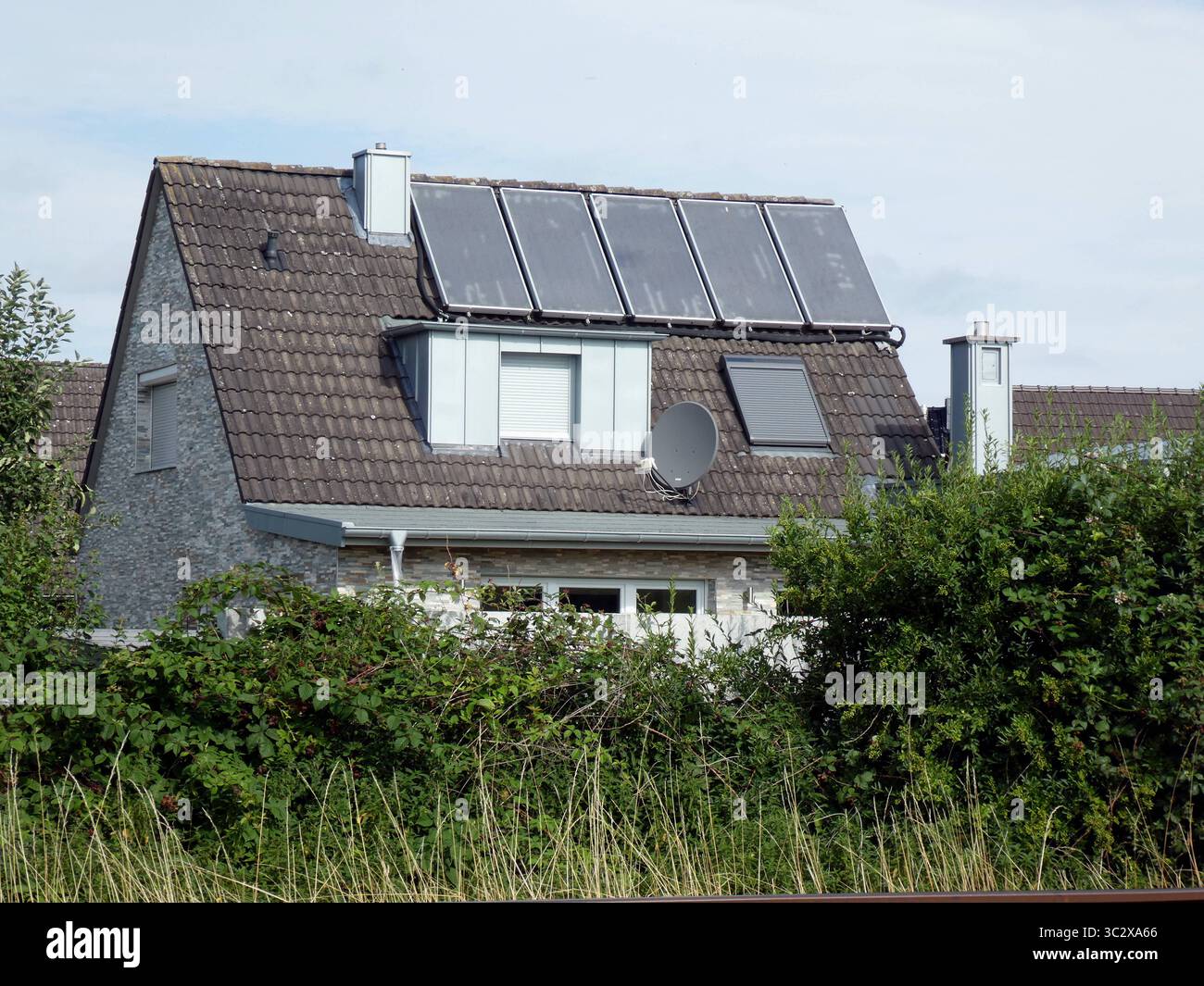 Einfamilienhaus mit Sonnenkollektoren, Solarpanele auf dem Dach. Heim ...