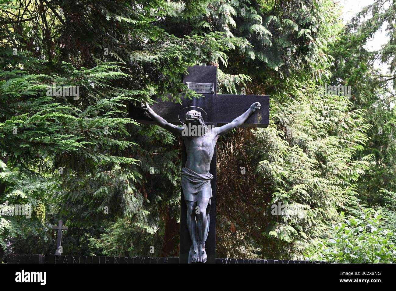 ein Kreuz mit dem gekreuigten Jesus wacht über ein Grab auf dem Kölner Prominentenfriedhof ...