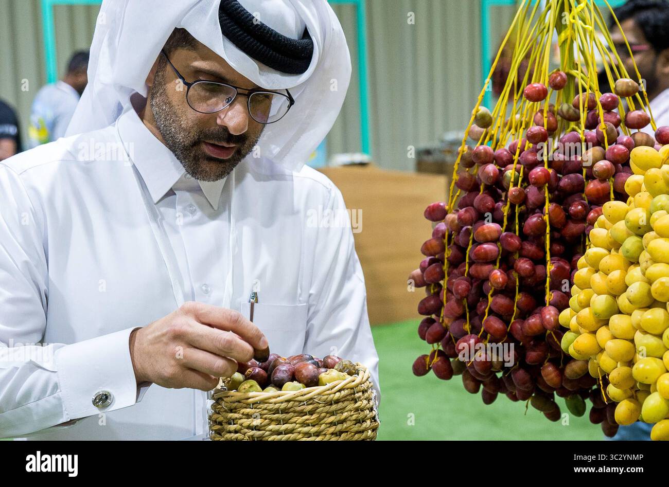 QATAR LOCAL DATES FESTIVAL 2025 A Qatari man looks at fresh dates at ...