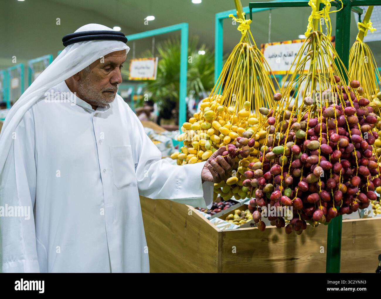 QATAR LOCAL DATES FESTIVAL 2025 A Qatari man looks at fresh dates at ...