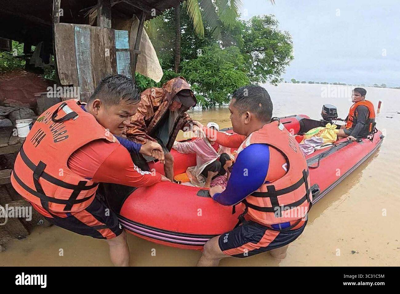 In this photo provided by the Philippine Coast Guard, rescuers assist a man to a rubber boat as ...